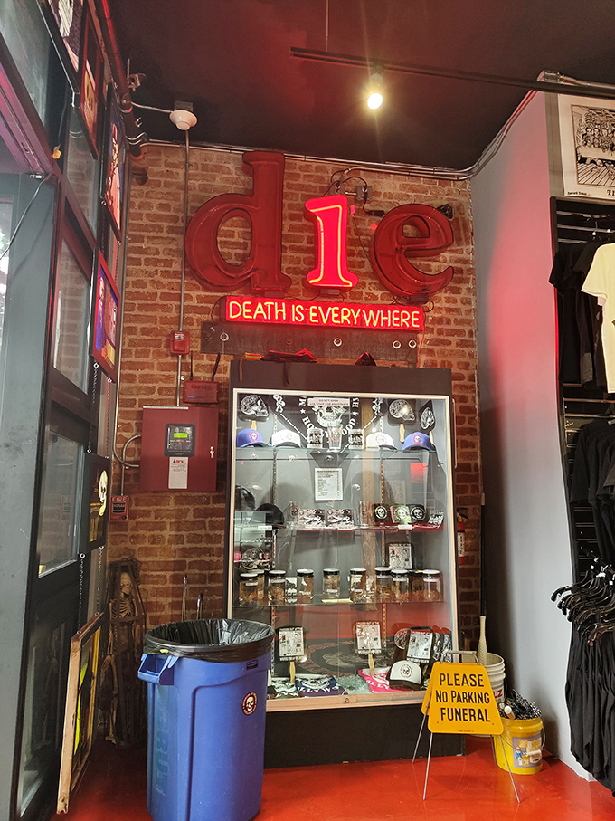 The glowing "die" sign illuminates merchandise displays with gallows humor. The "No Parking Funeral" sign adds an extra touch of dark comedy.