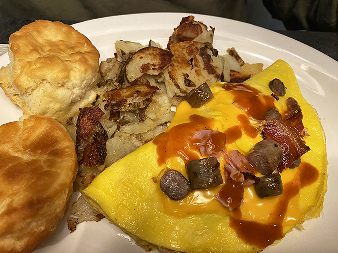 An omelet that's seen things&mdash;namely cheese, bacon, and vegetables&mdash;alongside a biscuit that's ready for its close-up.