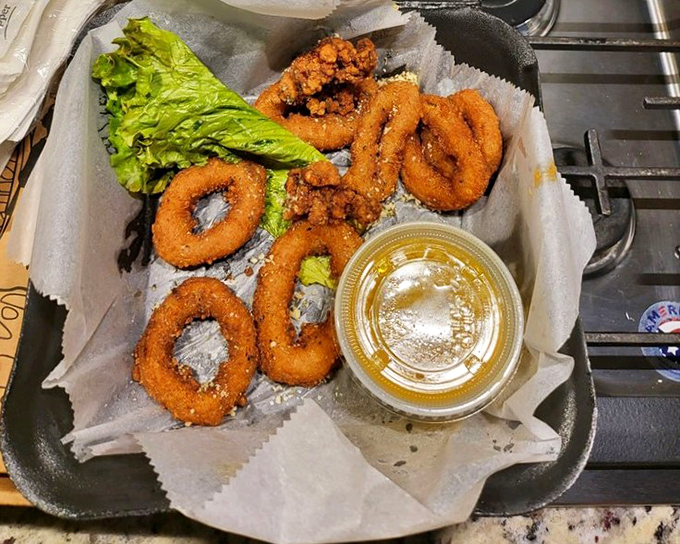 Golden-fried onion rings with that perfect crunch factor—the kind that makes conversation stop mid-sentence while everyone reaches for another.
