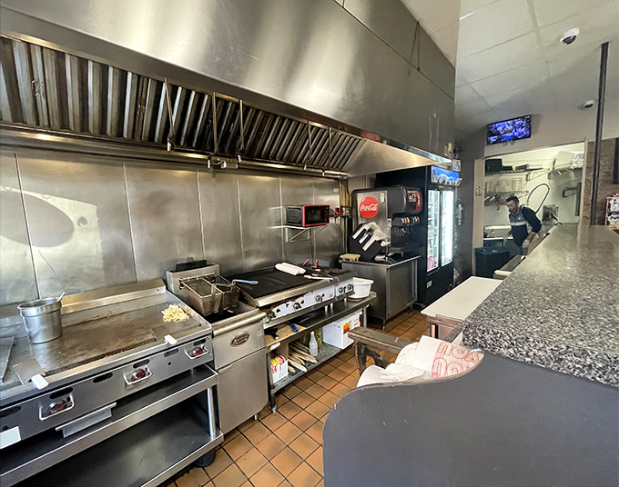 The open kitchen reveals the battlefield where sandwich greatness is forged daily with stainless steel precision.