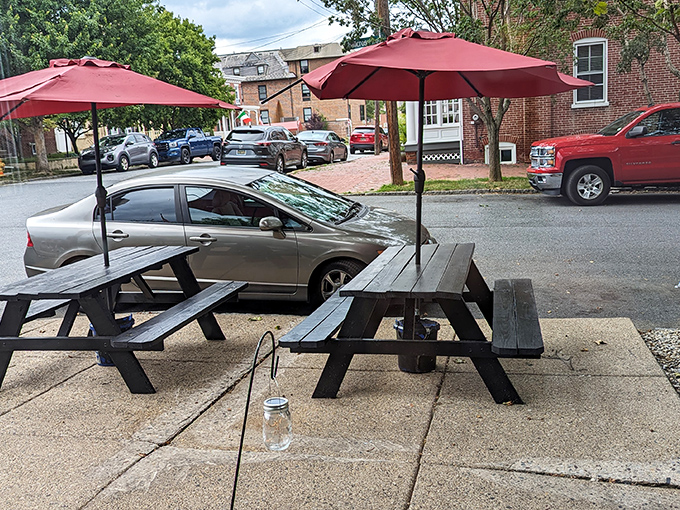 Red umbrellas shade picnic tables outside, creating an urban oasis where summer lunches stretch lazily into afternoon conversations.
