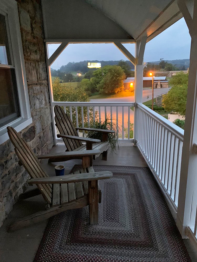 The porch at dusk offers Adirondack chairs and peaceful views. As darkness falls, it's easy to imagine travelers seeking this same refuge centuries ago.