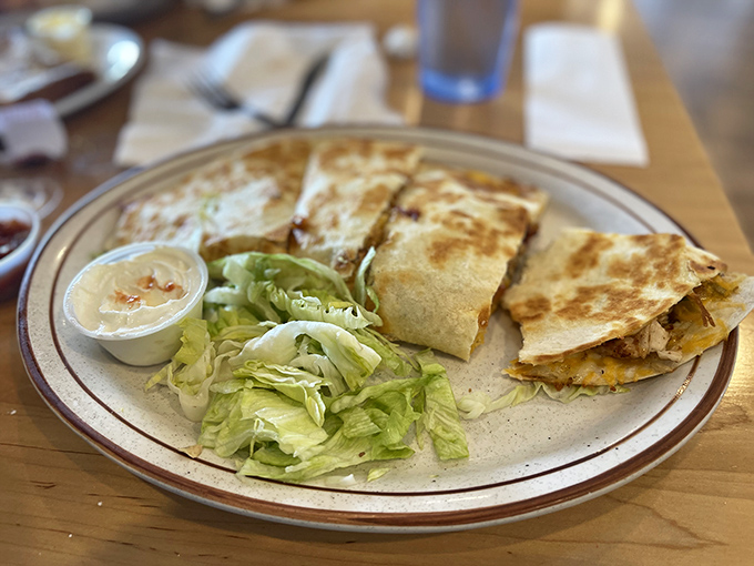 A quesadilla that doesn't skimp on the cheese, served with a side of lettuce that's clearly just there for moral support.