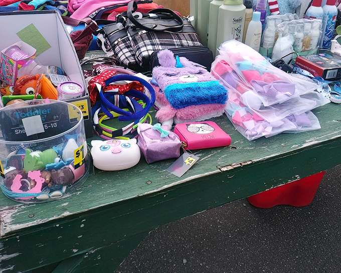 Childhood nostalgia meets practical necessities on this eclectic table. From plush toys to toiletries, the flea market's randomness is its charm.