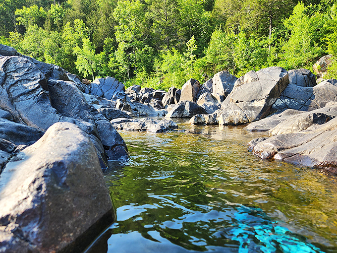 Crystal clear waters reflect summer skies between smooth stone sentinels. Nature's infinity pool predates the concept by about a billion years.