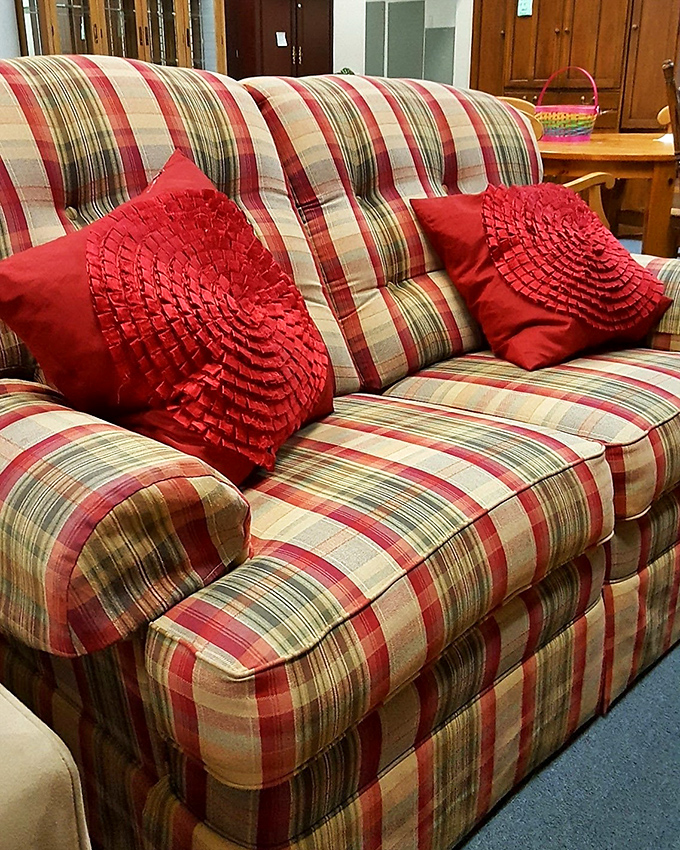 This plaid loveseat with decorative pillows isn't just sitting there &ndash; it's auditioning for the role of "favorite napping spot" in your living room.