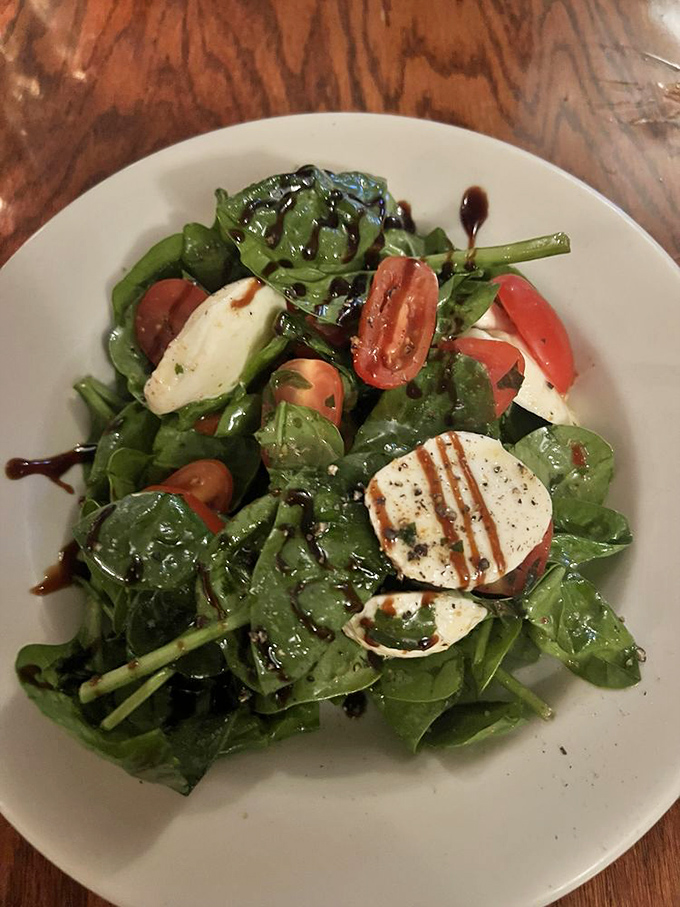 A spinach salad that somehow makes eating your greens feel like an indulgence rather than a virtue.