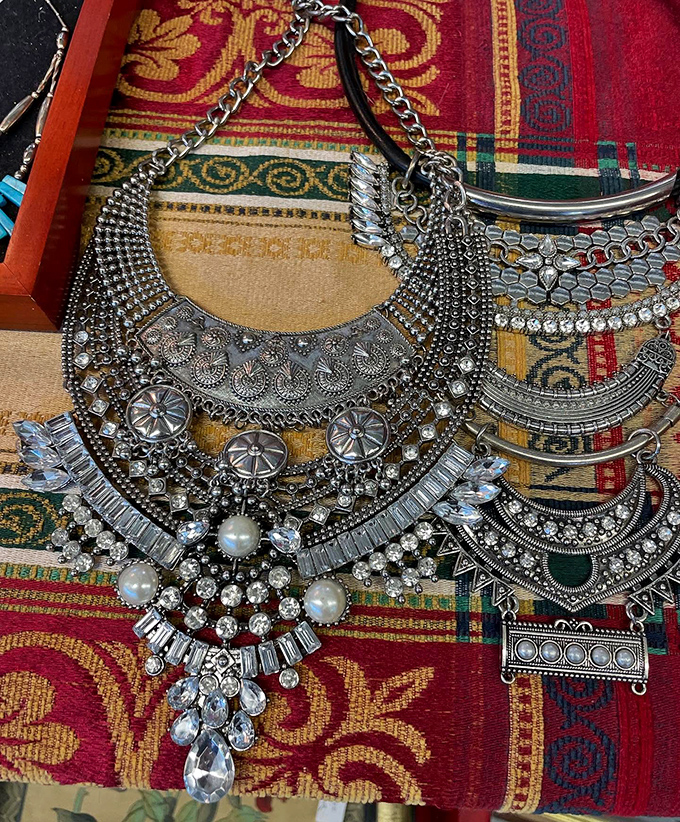 Statement necklaces that speak volumes, arranged on vintage textiles. Accessories with attitude that transform any basic outfit.