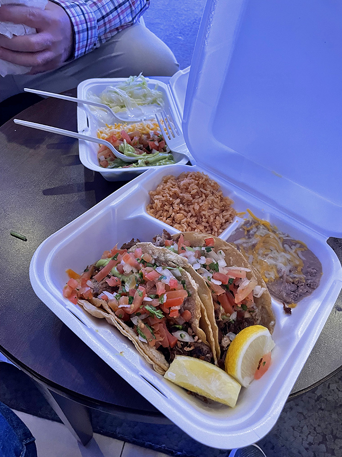 Taco perfection on display. These street-style beauties come dressed with fresh cilantro and onion, with lemon wedges standing by for duty.
