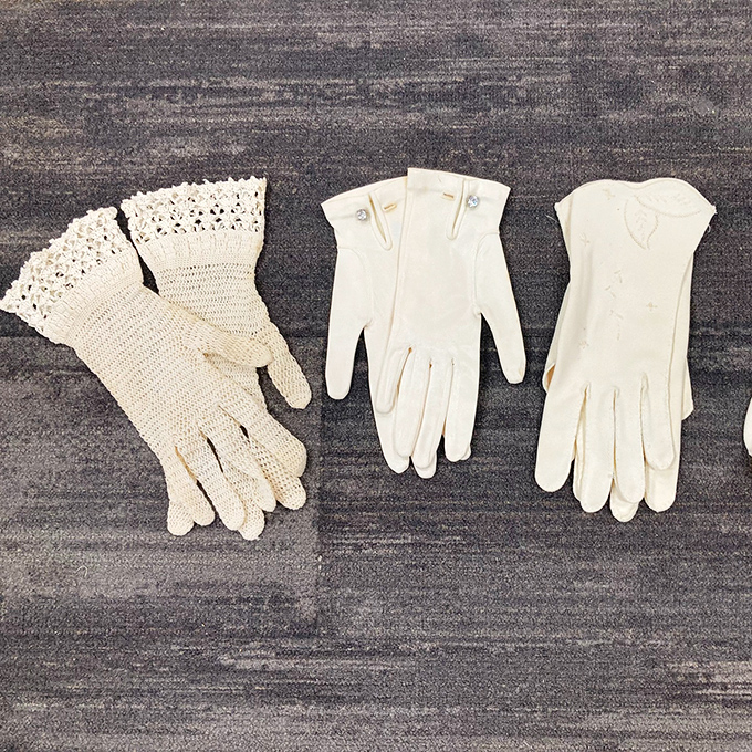 Delicate vintage gloves tell stories of elegant afternoons and formal occasions – wearable history at thrift store prices.