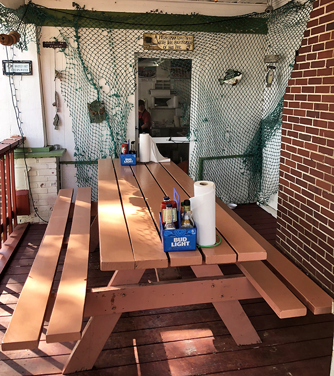 This picnic table, draped in fishing net, isn't just seating&mdash;it's your personal battlefield for the delicious crab confrontation that awaits.