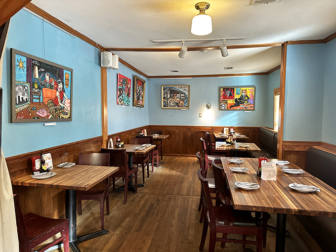 Blue walls and local artwork create a dining room that feels like eating in a gallery where the real masterpieces arrive on plates.