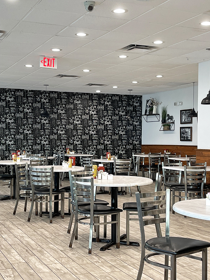 The coffee-themed wall adds a caffeinated personality to this dining area, where tables await their next conquest of hungry morning warriors.