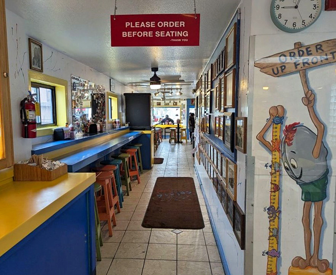 The narrow hallway feels like a secret passage to flavor town. The "Order Up Front" sign might as well say "Abandon diet, all ye who enter here."