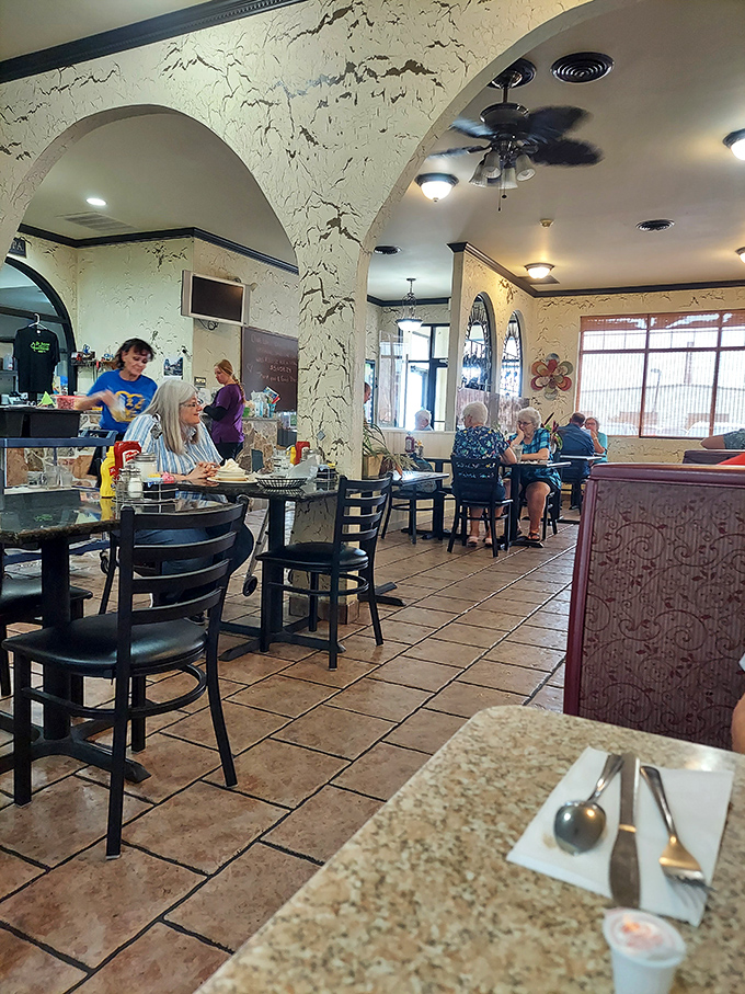 Textured walls and arched doorways create distinct dining zones without sacrificing the communal spirit. Every table feels like the best seat in the house.