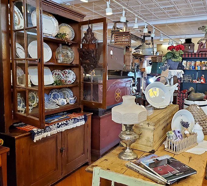 This antique china cabinet showcases delicate porcelain treasures alongside practical kitchenware—beauty and function preserved through generations.