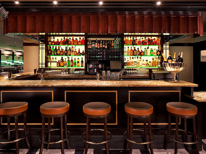 At Osso's handsome bar, bottles glow like jewels against dark wood, promising cocktails crafted with the same attention as the kitchen's prime cuts.