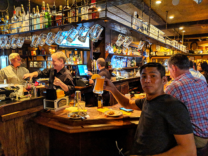 The bar area hums with the energy of people making good decisions about their evening, with beer glasses raised in a toast to tradition.