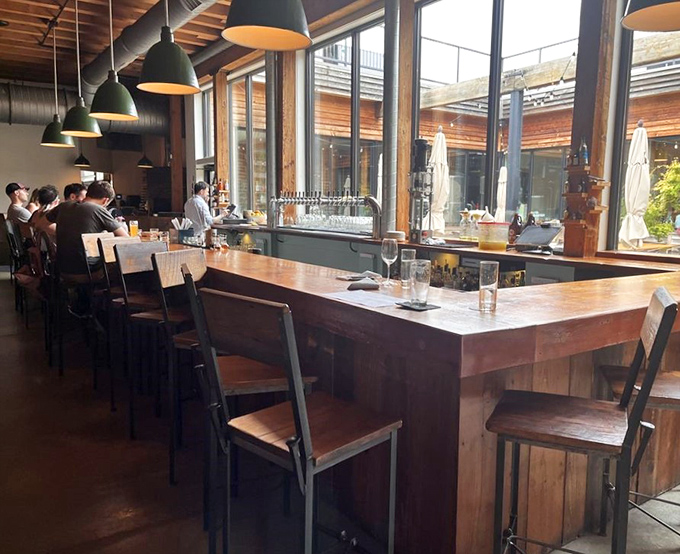 The bar invites lingering conversations over craft beers. Sunlight streams through windows, illuminating the handcrafted wooden counter where memories are made.