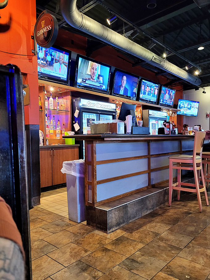 The bar area: where sports commentary flows as freely as the beer, and strangers become friends over shared buffalo sauce experiences.