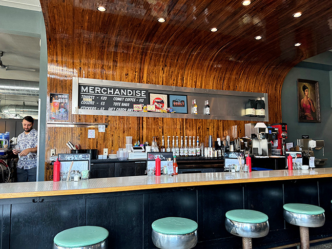 The curved wooden ceiling and mint-green barstools create a space that's both retro and timeless. Perfect for solo diners watching culinary magic unfold.