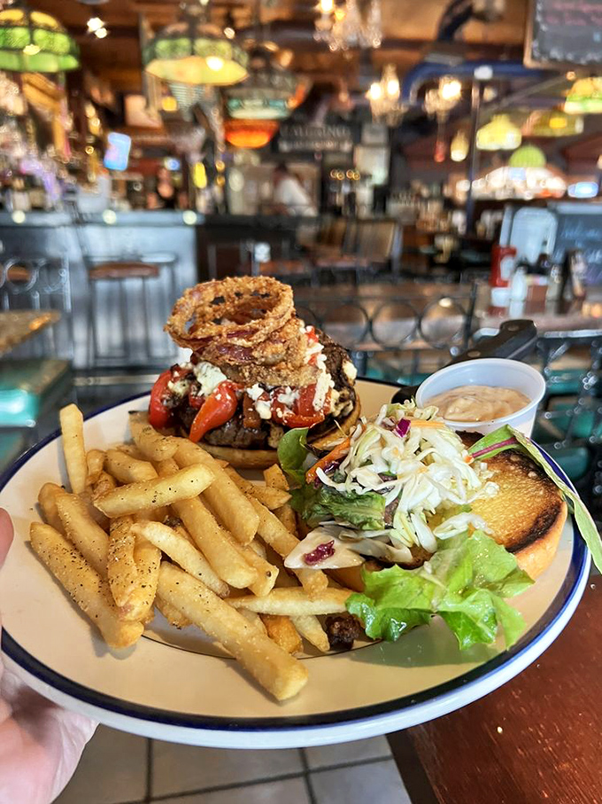 This isn't just a burger; it's a towering achievement of beef, toppings, and those crispy onion rings perched on top like a crown.