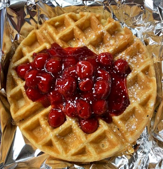 A waffle that doesn't need to swipe right&mdash;it's already found its perfect match with those glistening cherries and a dusting of powdered sugar.