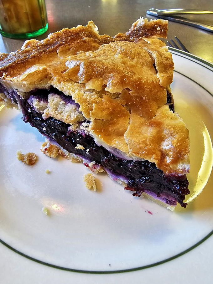 Homemade blueberry pie slice showcasing real fruit and flaky crust – dessert the way it should be.
