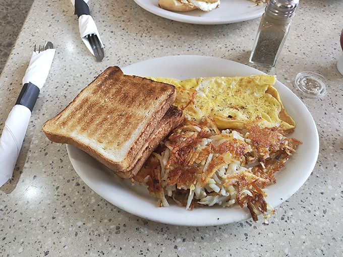 The holy trinity of breakfast: perfectly toasted bread, fluffy eggs, and crispy hash browns. Simple pleasures executed with diner precision.
