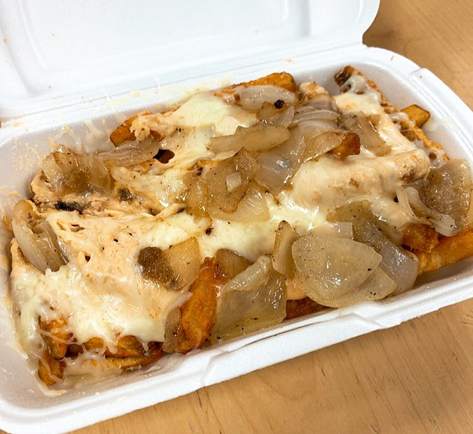 These loaded fries don't just satisfy hunger - they launch a full-scale flavor assault with melted cheese and caramelized onions leading the charge.