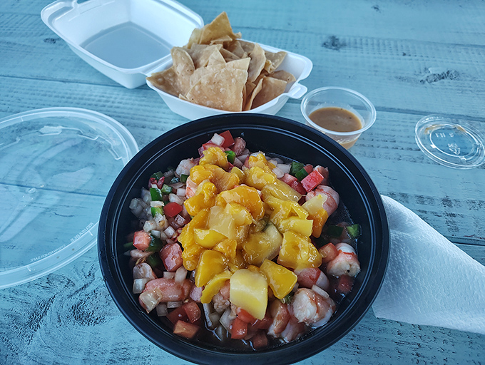 Ocean meets garden in this vibrant ceviche. Fresh shrimp, diced tomatoes, and what appears to be mango create a tropical party in a bowl.