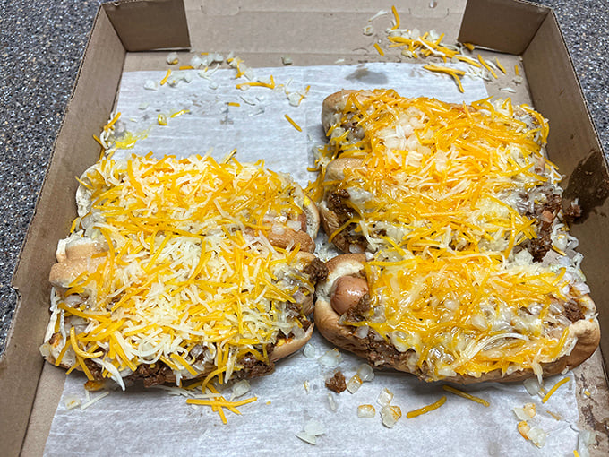 Two cheese-smothered coneys in their cardboard chariot, ready to deliver street food bliss without requiring a single passport stamp.