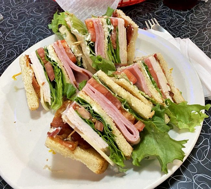 A club sandwich stacked higher than your weekend to-do list, with layers that tell a delicious story between toasted bread.