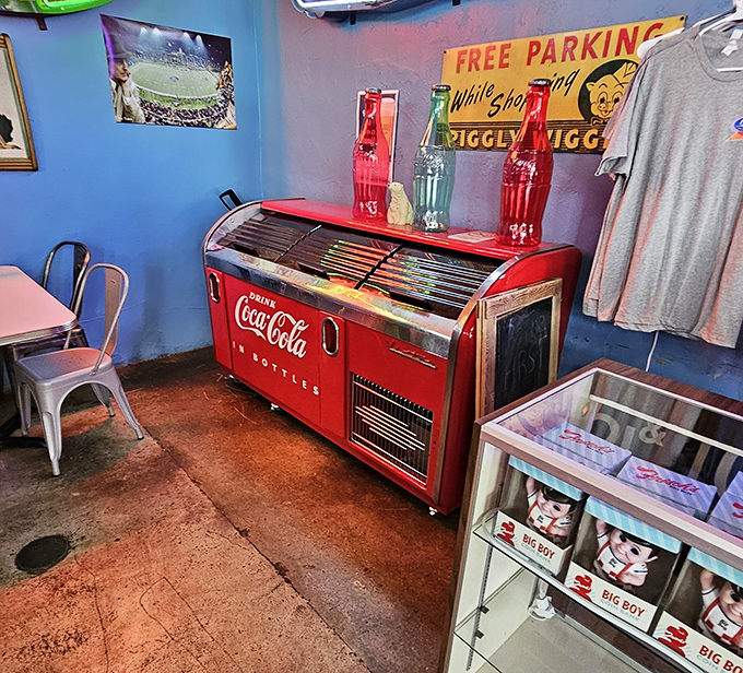 A vintage Coca-Cola cooler adds authentic retro charm to this automotive-themed dining experience and atmosphere.