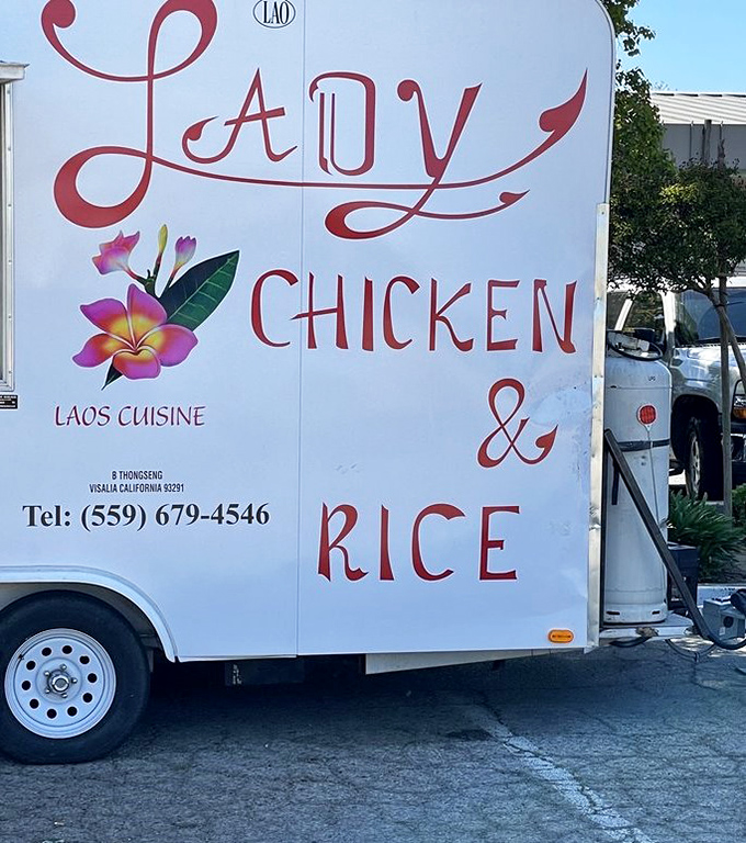 The side of the truck proudly announces "Laos Cuisine" with a phone number that deserves a spot in your contacts under "Emergency Deliciousness."
