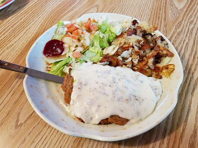 Country fried steak smothered in gravy with a side of perfectly crispy potatoes. A plate that says "nap time is coming" in the most delicious way.