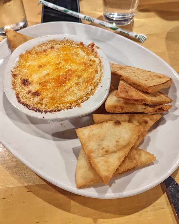 Bubbling crab dip that creates momentary silence at the table as everyone contemplates how to maximize their share without appearing greedy.