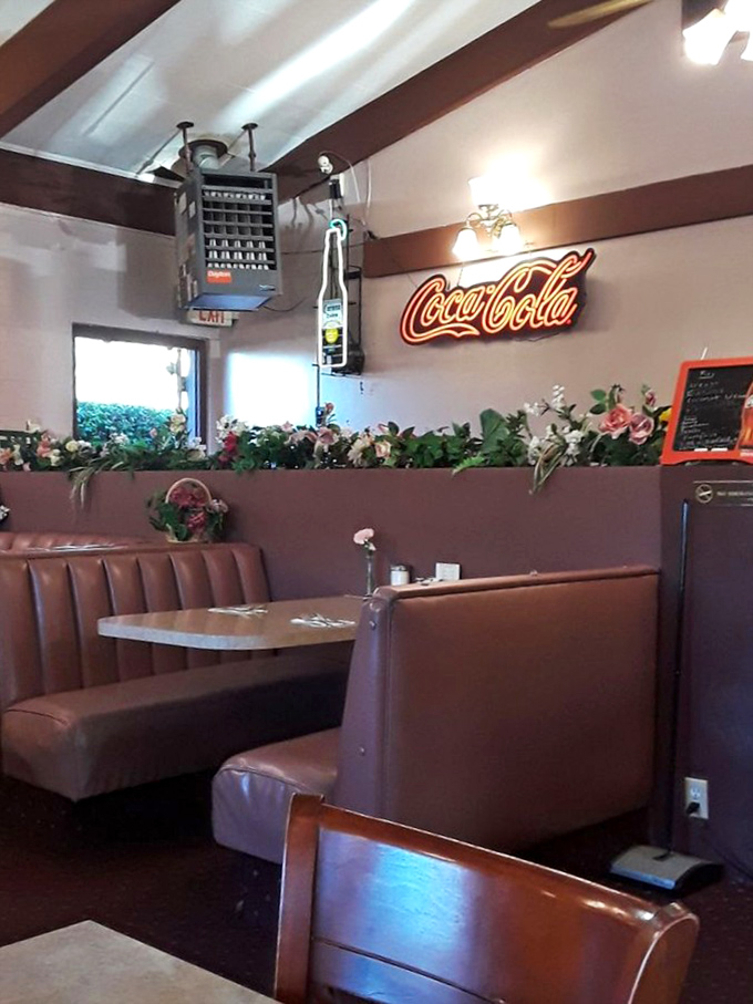 The Coca-Cola sign glows like a beacon of nostalgia above booths that have witnessed countless family celebrations and first dates.