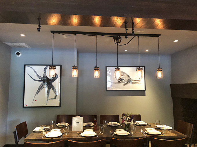 The private dining area feels like a modern art gallery meets intimate dinner party, where pendant lighting casts a warm glow over carefully curated artwork.