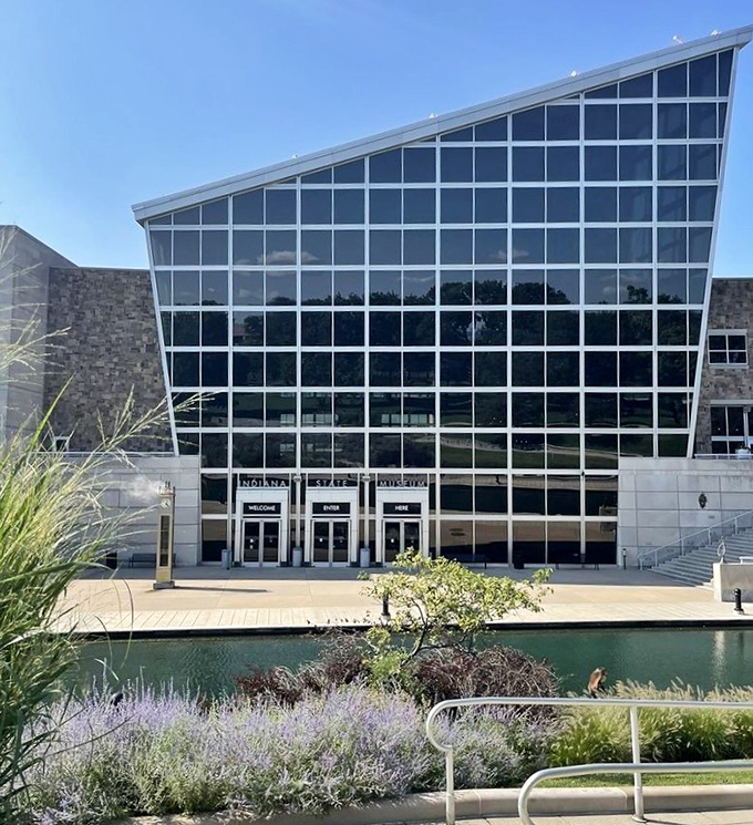 The museum's dramatic glass entrance reflects both water and sky, inviting visitors into a space where Indiana's story unfolds in unexpected ways.