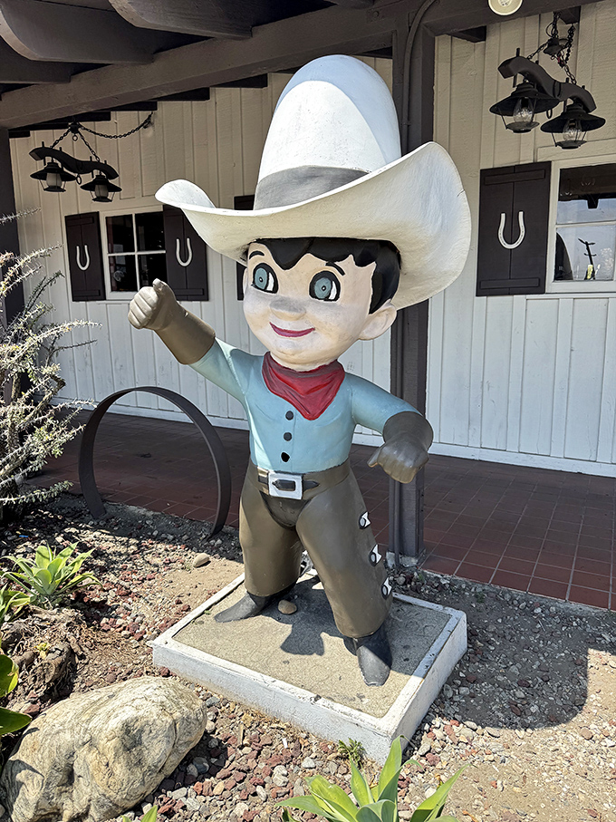 The cowboy mascot greets visitors with a friendly tip of the hat, promising Western hospitality and steaks that would make any trail boss proud.