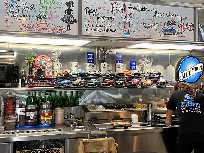 Behind the counter, where the magic happens. That collection of model cars isn't just decoration &ndash; it's a timeline of American automotive history.