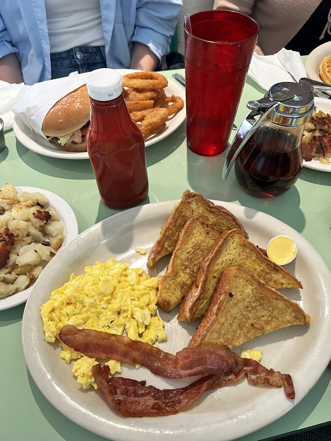 French toast triangles standing at attention next to scrambled eggs and bacon. The breakfast formation that starts your day with a salute.