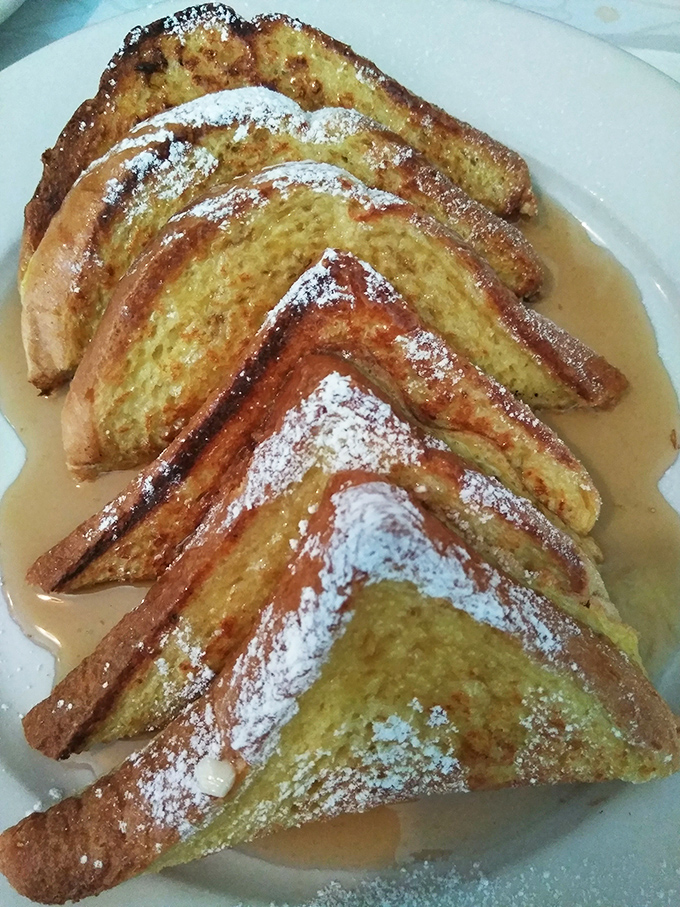 French toast that's achieved the impossible balance of crispy exterior and custardy interior. That dusting of powdered sugar isn't decoration&mdash;it's a blessing from above. 