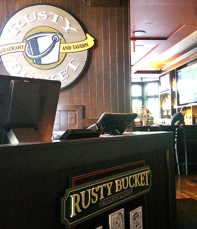 The Rusty Bucket's logo and reception area &ndash; where many a friendship has begun with the phrase "the wait is about 20 minutes."