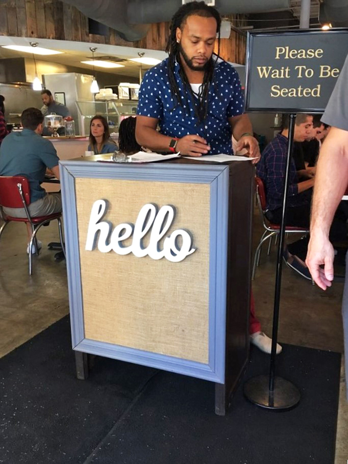 The host stand's cheerful "hello" sign sets the tone for the warm welcome that awaits&mdash;your first hint that this isn't just another breakfast joint.
