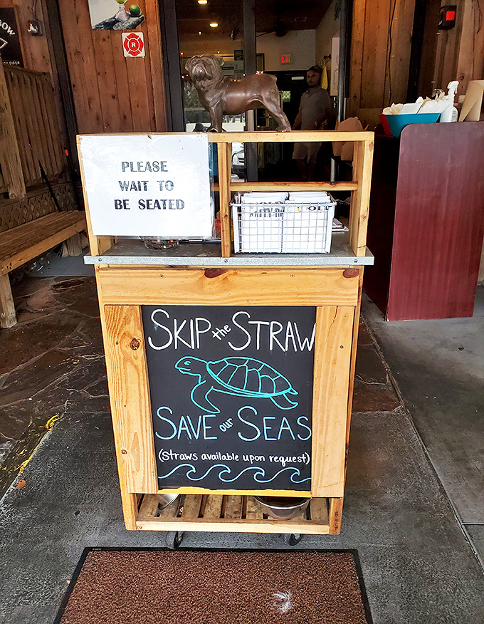 "Skip the Straw, Save our Seas" says the sign, with a bronze bulldog standing guard&mdash;even paradise has house rules worth following.