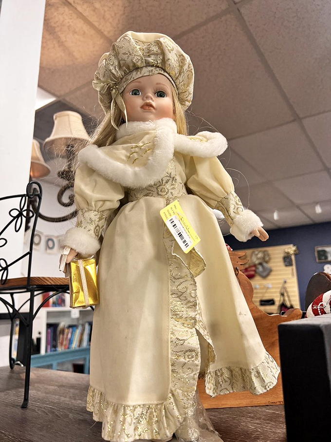 This porcelain doll stands sentinel among the collectibles, her pristine condition suggesting decades spent in a glass cabinet rather than a playroom.