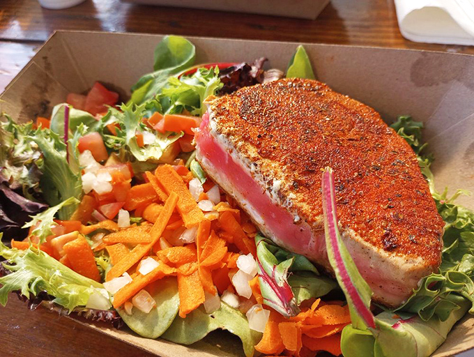 Seared ahi tuna perched atop fresh greens &ndash; where healthy eating and indulgence find their delicious middle ground.
