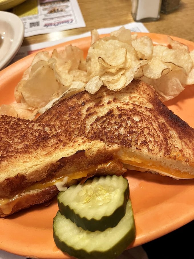 The humble grilled cheese elevated to art form &ndash; golden, buttery bread giving way to melted perfection, with crisp pickle slices offering tangy contrast.